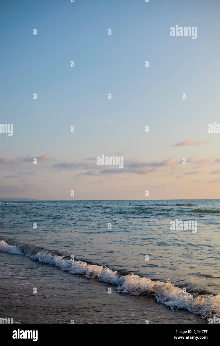 A vertical shot of beautiful splashing sea waves with the stunning ...