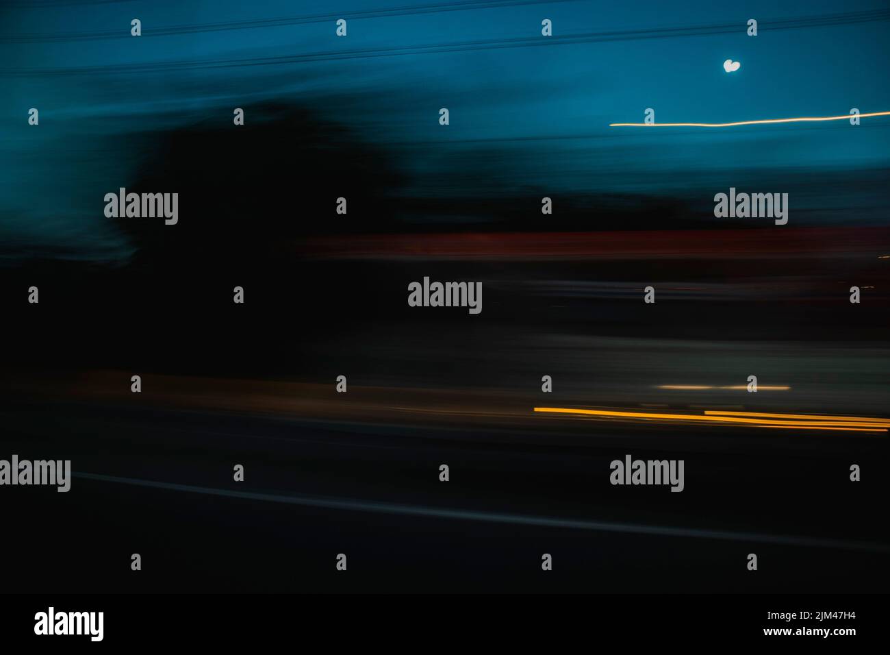A timelapse of traffic lights on a road with dark night sky background ...
