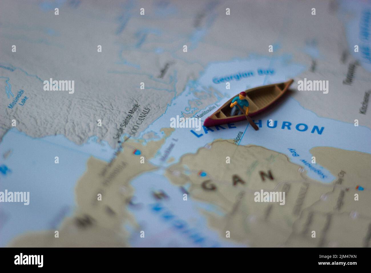 A boat figurine with a male sailor on a map Stock Photo - Alamy