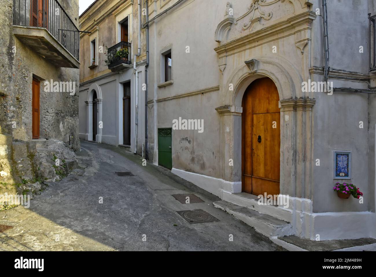 A narrow street with painted murals in a village of Calabria region ...