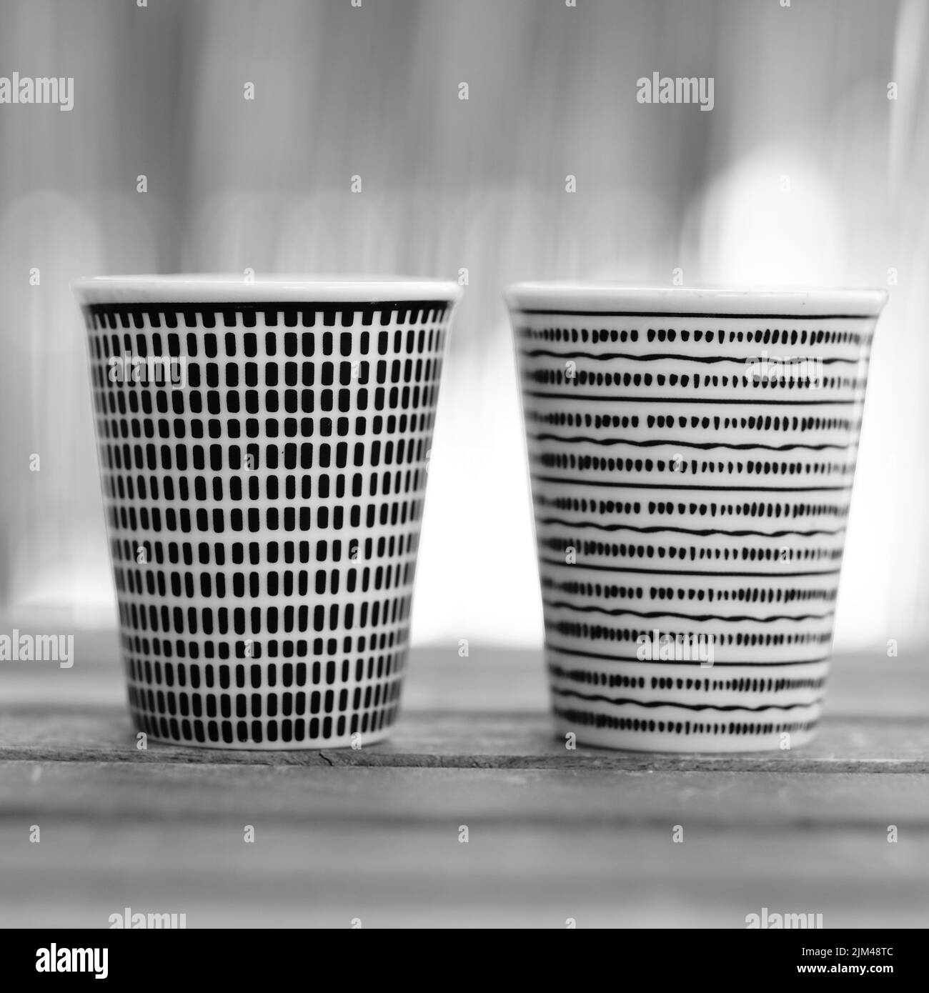 A vertical grayscale closeup of paper espresso cups on the bench Stock ...