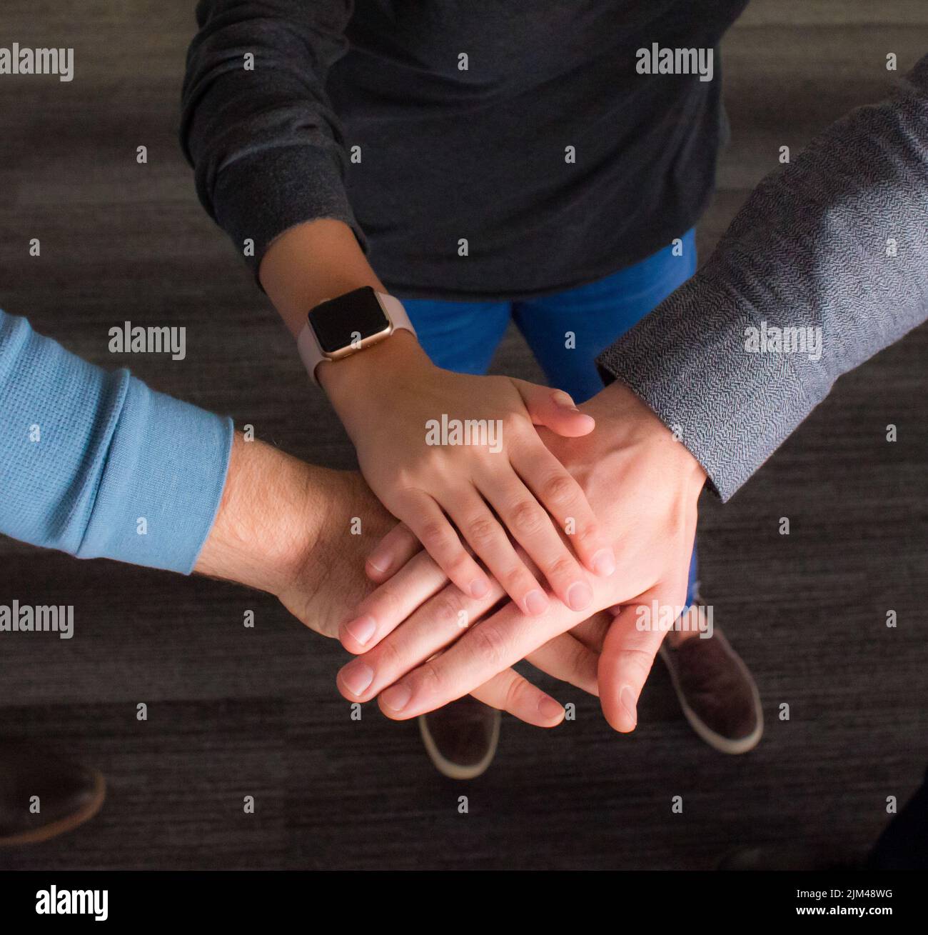 The team members stacking hands together Stock Photo - Alamy
