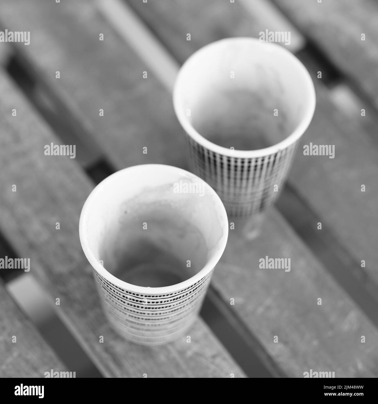 A vertical grayscale top view of paper espresso cups on the bench Stock ...