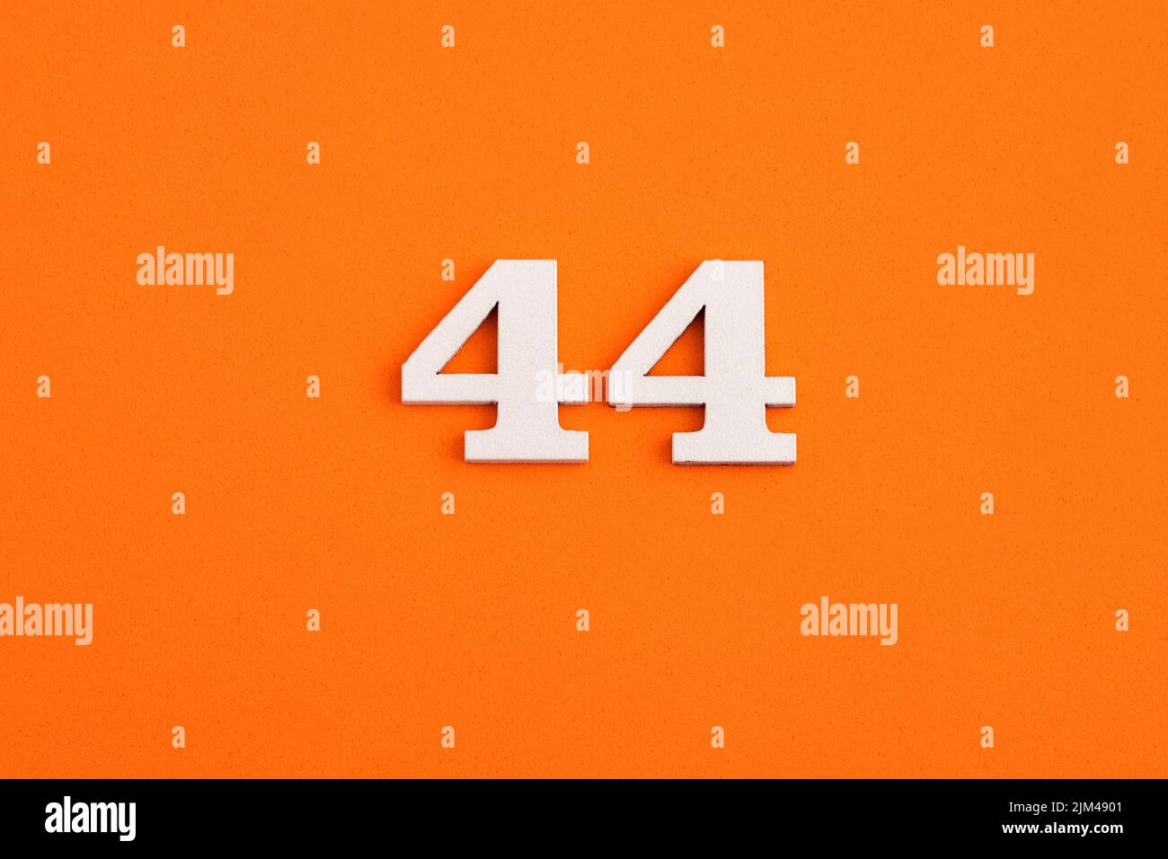 White wooden number 44 on eva rubber orange background Stock Photo - Alamy