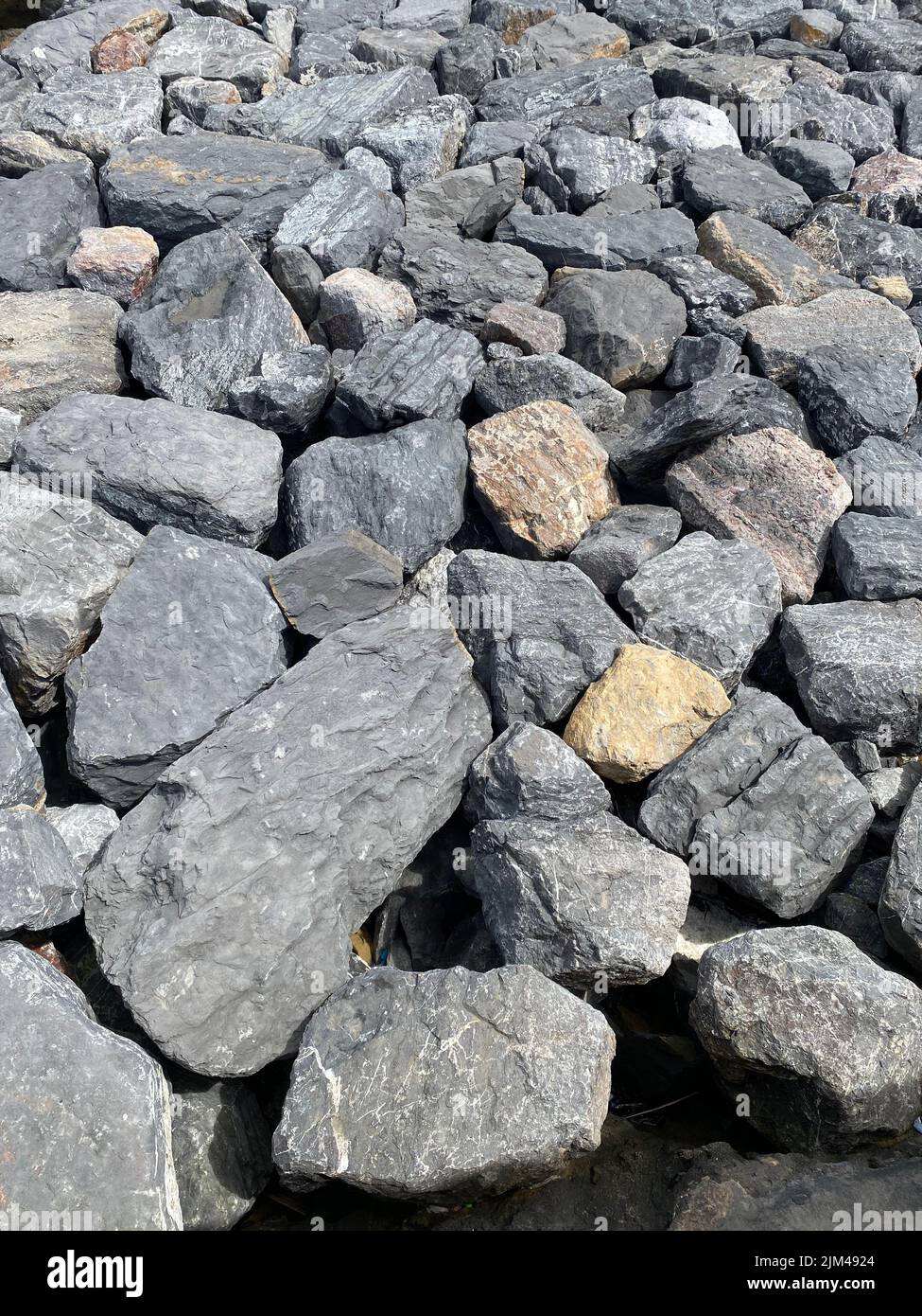 Big rocks grey stones to prevent sea water flowing Stock Photo - Alamy