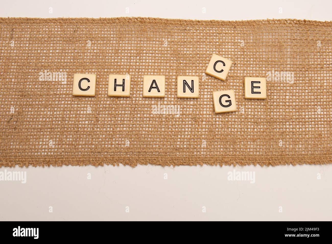 Change into Chance concept in letter tiles laid on Hessian jute cloth ...