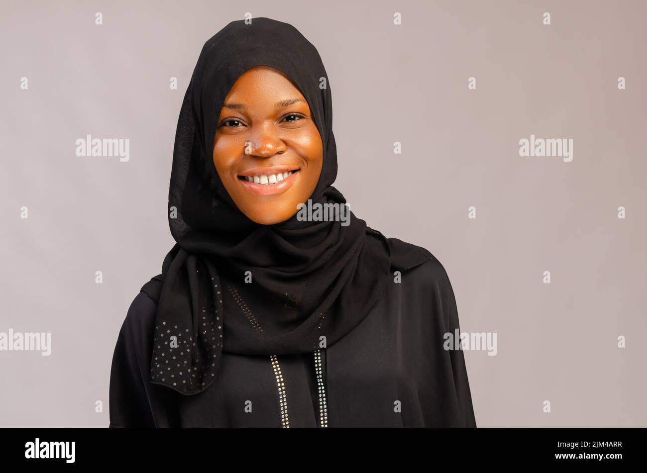 A beautiful African Muslim lady happy and smiling in a black outfit ...