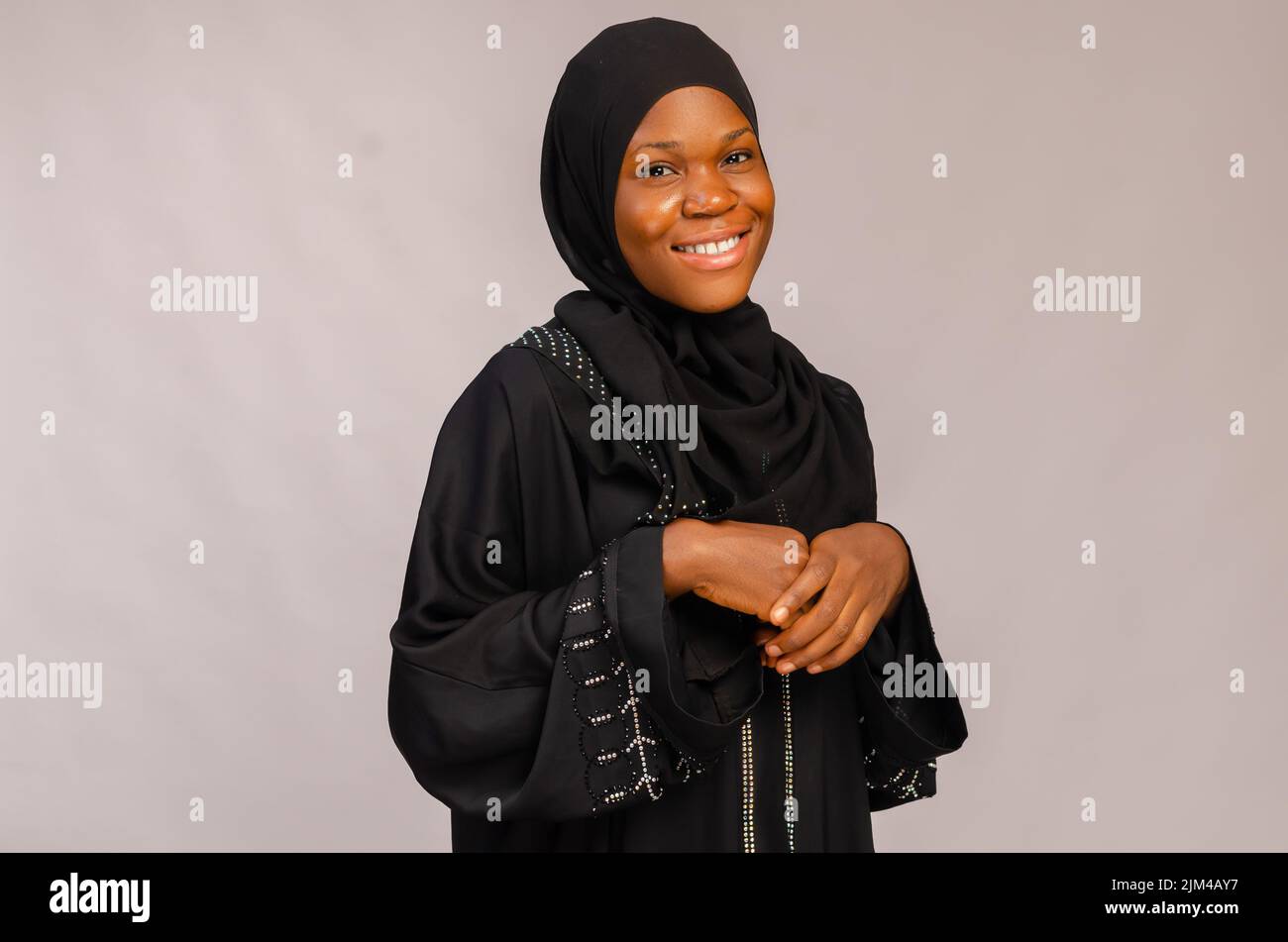 A beautiful African Muslim lady happy and smiling in a black outfit ...