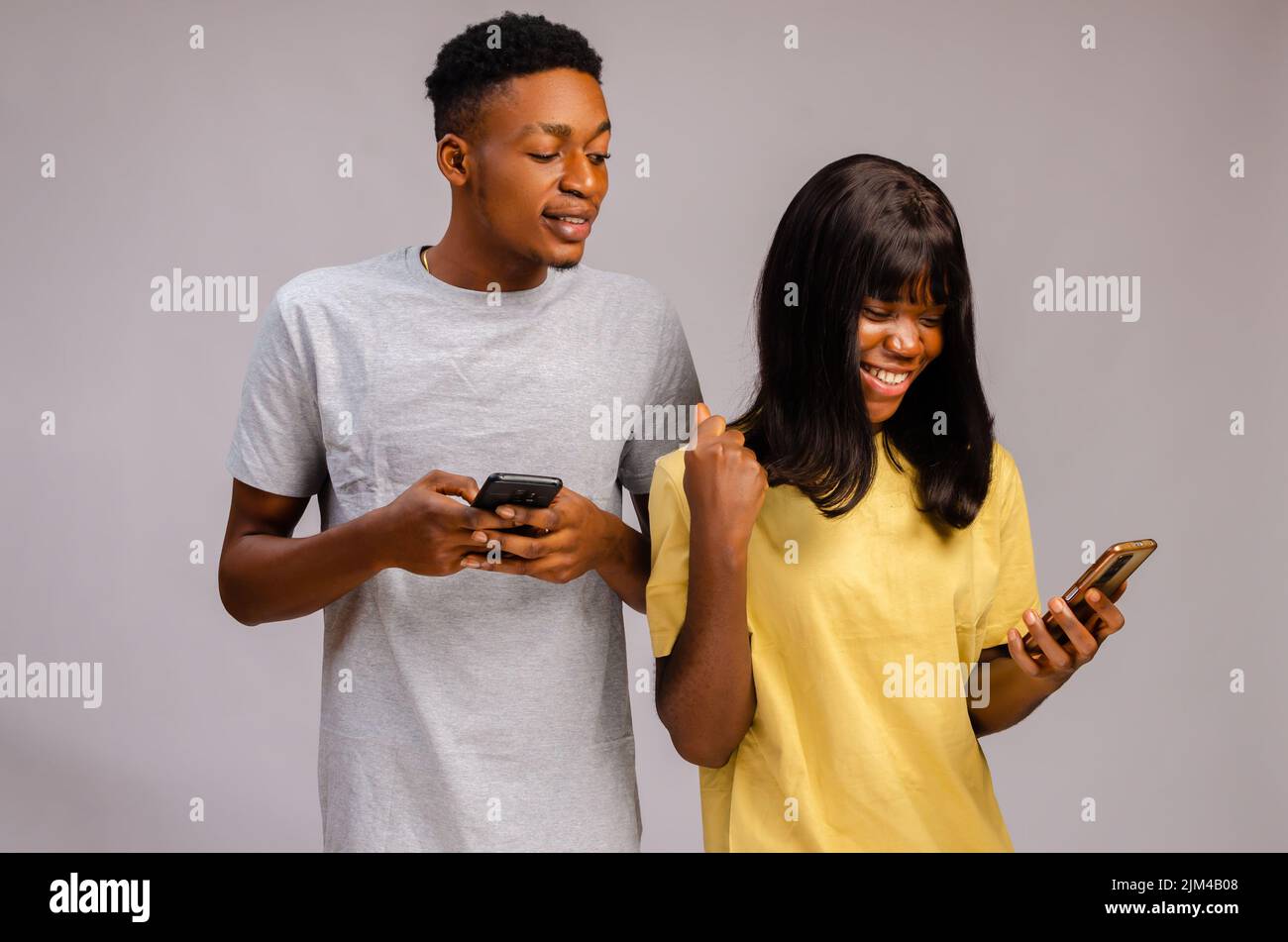 A Portrait of an African couple focused and using gadgets spying on ...