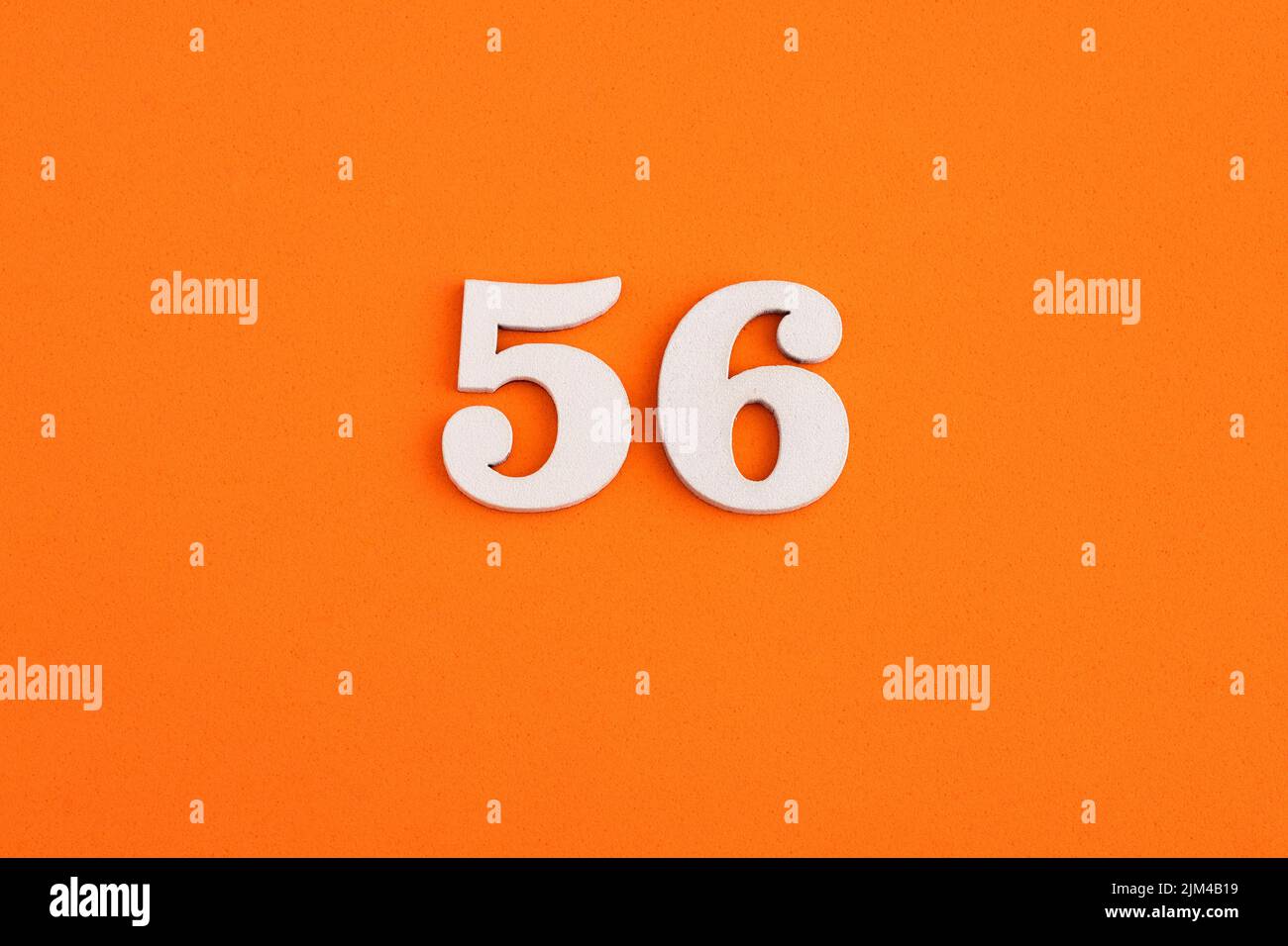 White wooden number 56 on eva rubber orange background Stock Photo - Alamy