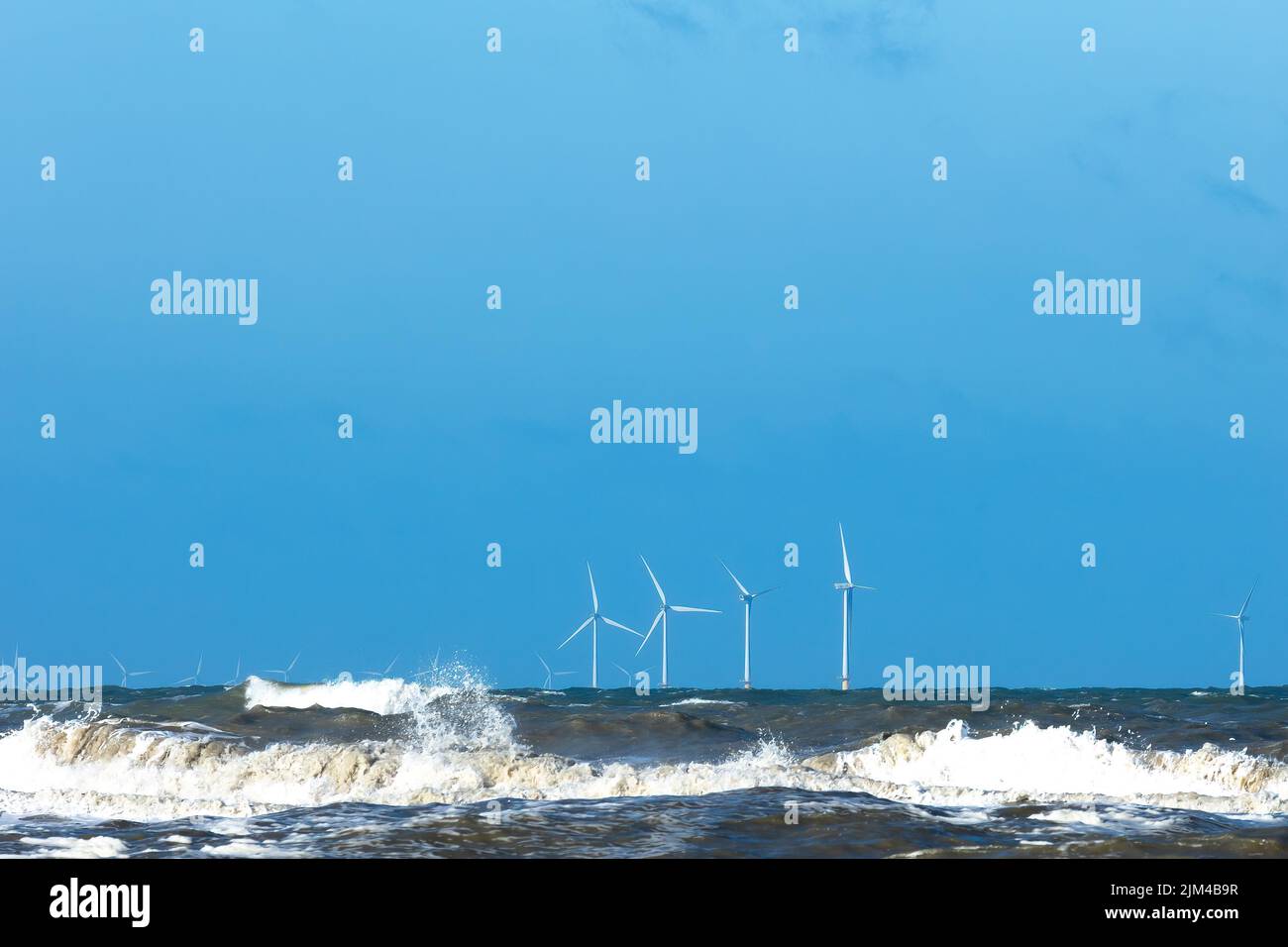 Offshore windmill park in a stormy north sea with spindrift waves Stock ...