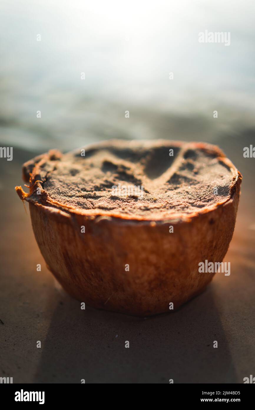 A vertical shot of a coconut shell with sand on a beach in Boracay ...