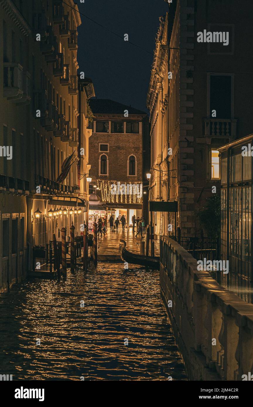 The Gondola canal with reflection surrounded by buildings in night ...