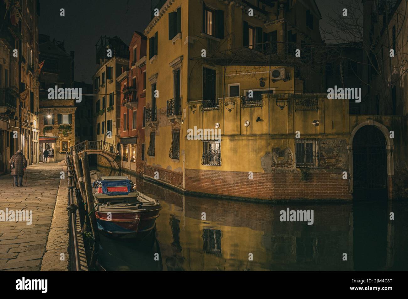 The Gondola canal with reflection surrounded by buildings in night ...