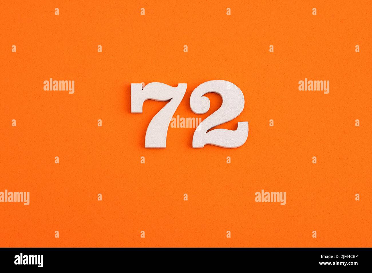 White wooden number 72 on eva rubber orange background Stock Photo - Alamy