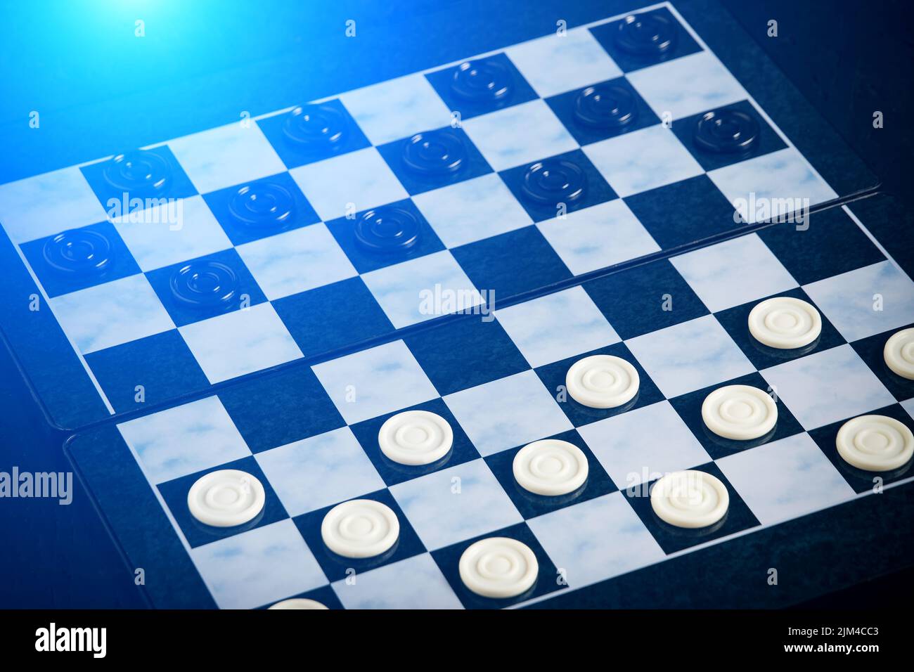 Checkers board with checkers illuminated with bright blue light Stock ...