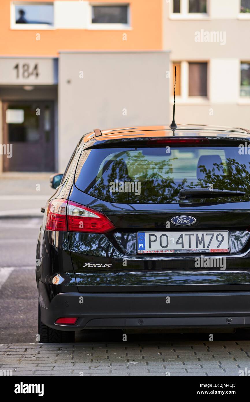 A Ford brand car parked on a parking place close by an apartment ...