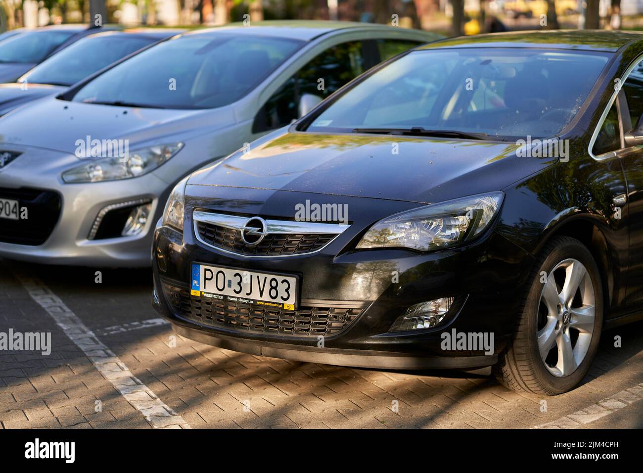 A row of parked cars including Opel by a sidewalk in the Stare Zegrze ...