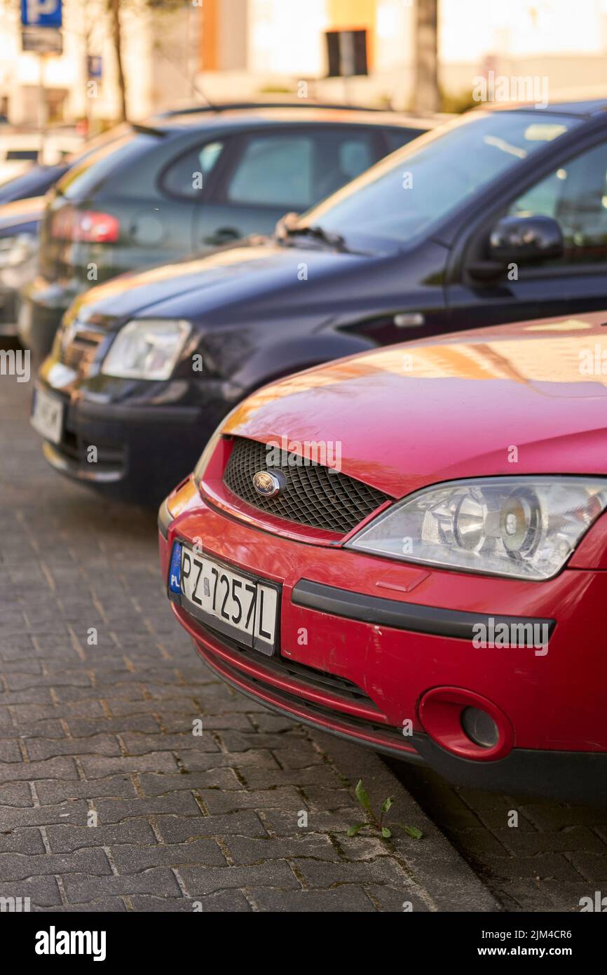 A vertical shot of a row of parked cars on parking places, including a ...