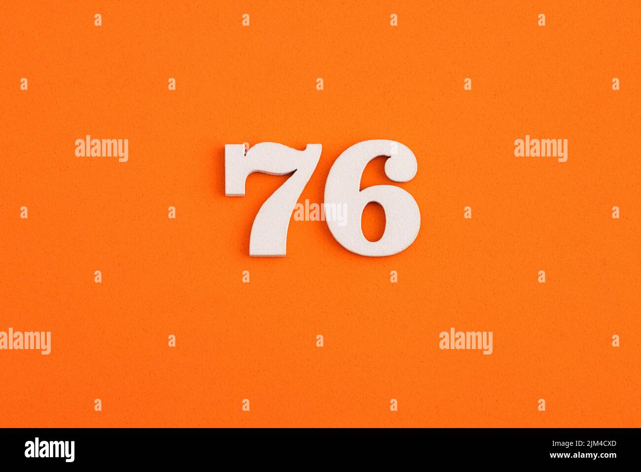 White wooden number 76 on eva rubber orange background Stock Photo - Alamy