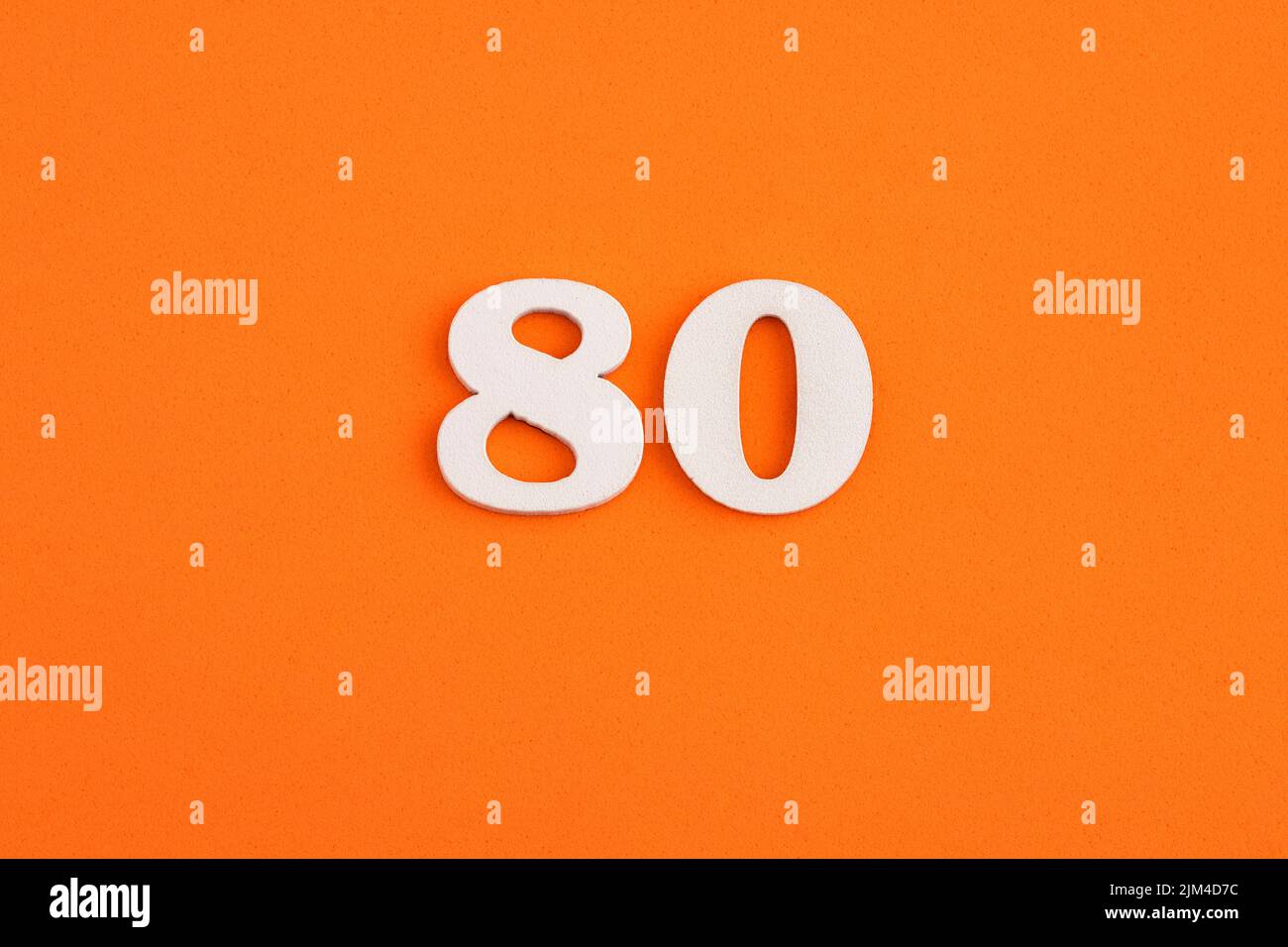 White wooden number 80 on eva rubber orange background Stock Photo - Alamy