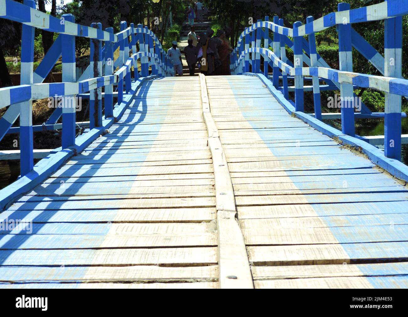 The blue striped wooden bridge in the park under sunlight Stock Photo ...