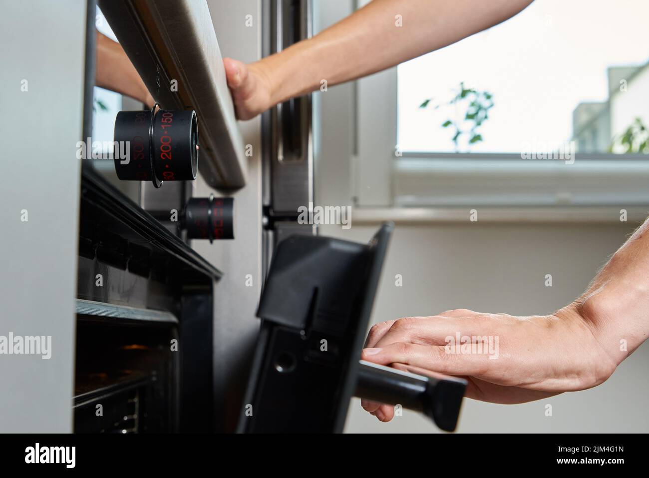 Female hand open electric oven door with handle, Woman using electric ...