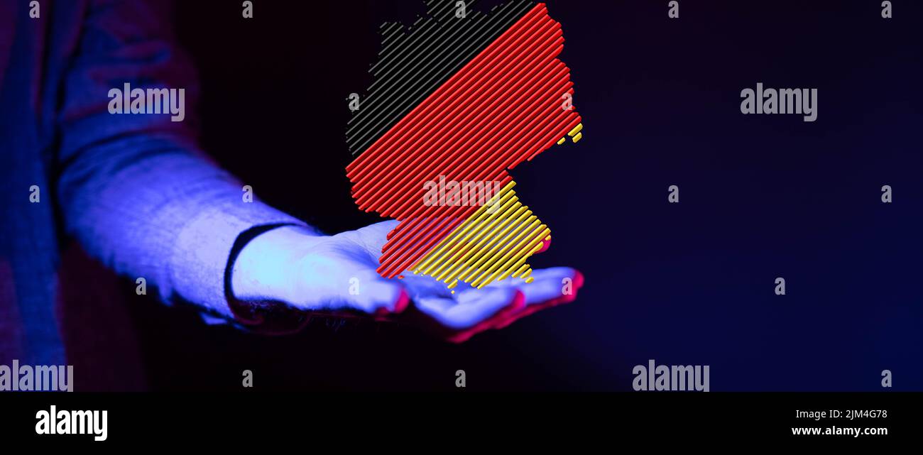 A hand holding a futuristic map of Germany colored with its flag on a ...