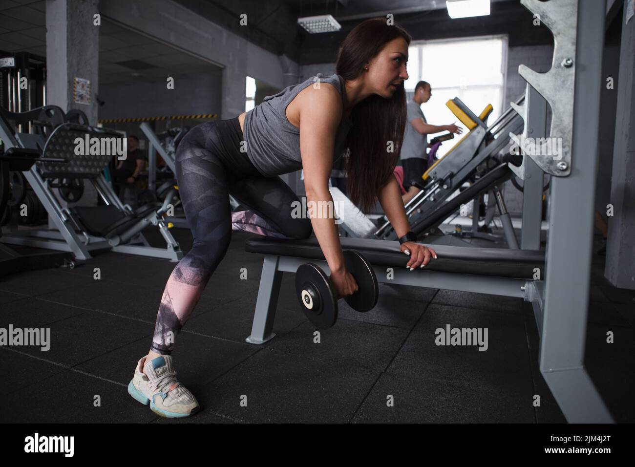 Full length shot of a female bodybuilder exercising with weights, doing ...