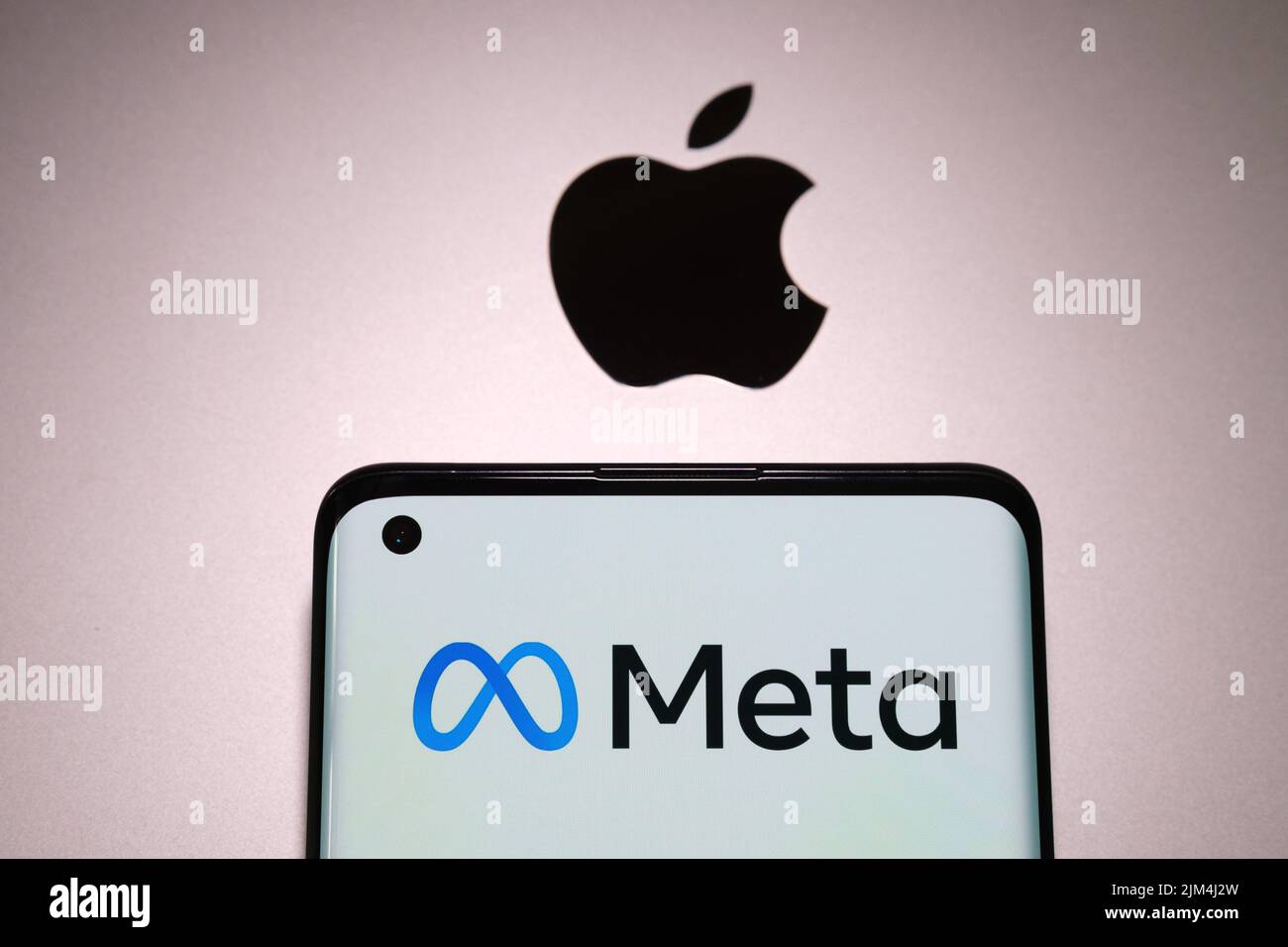Meta company logo seen on smartphone which is plased on top of macbook ...