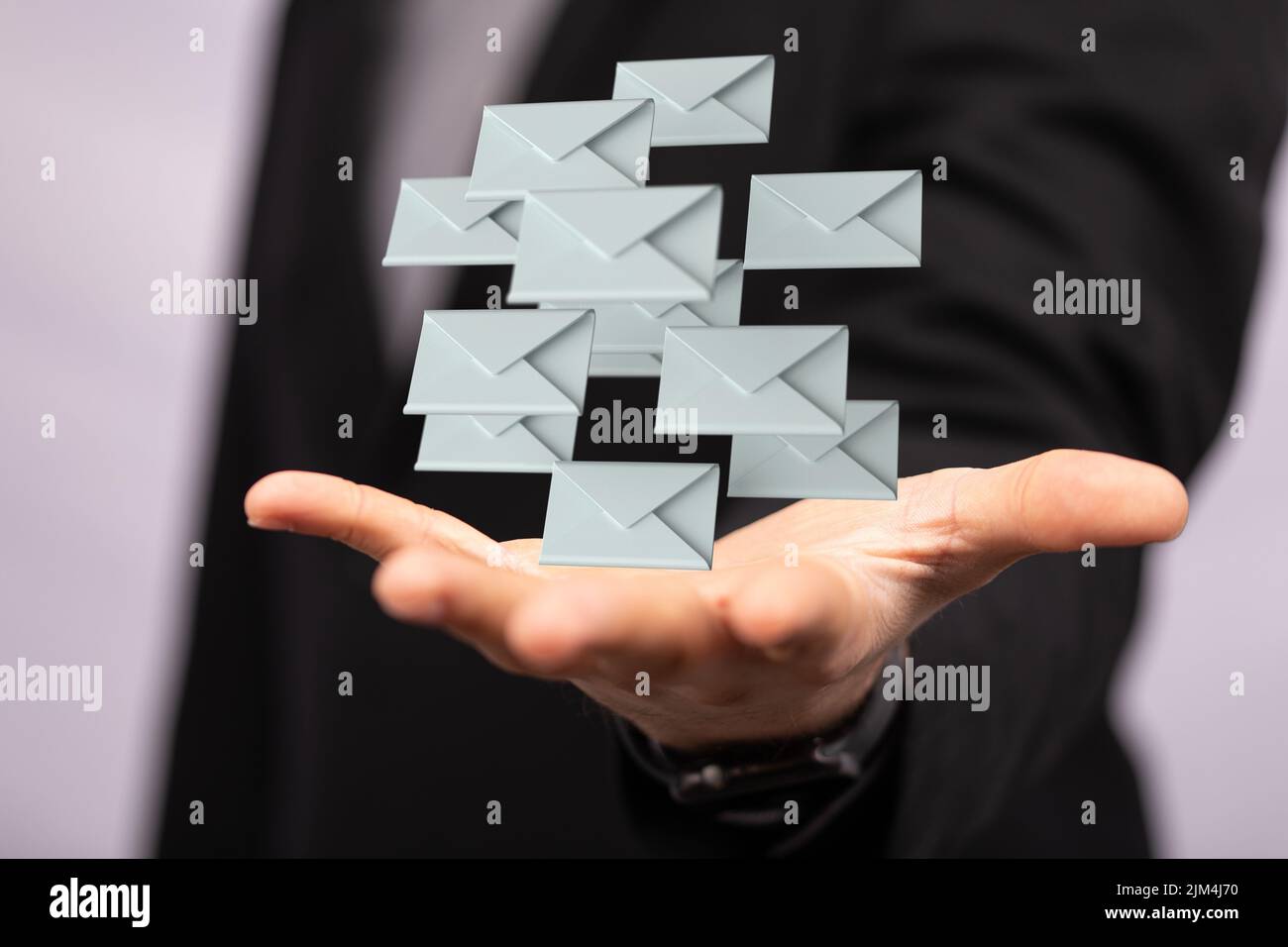 A many email icons concept in a businessman hand with blurred male ...