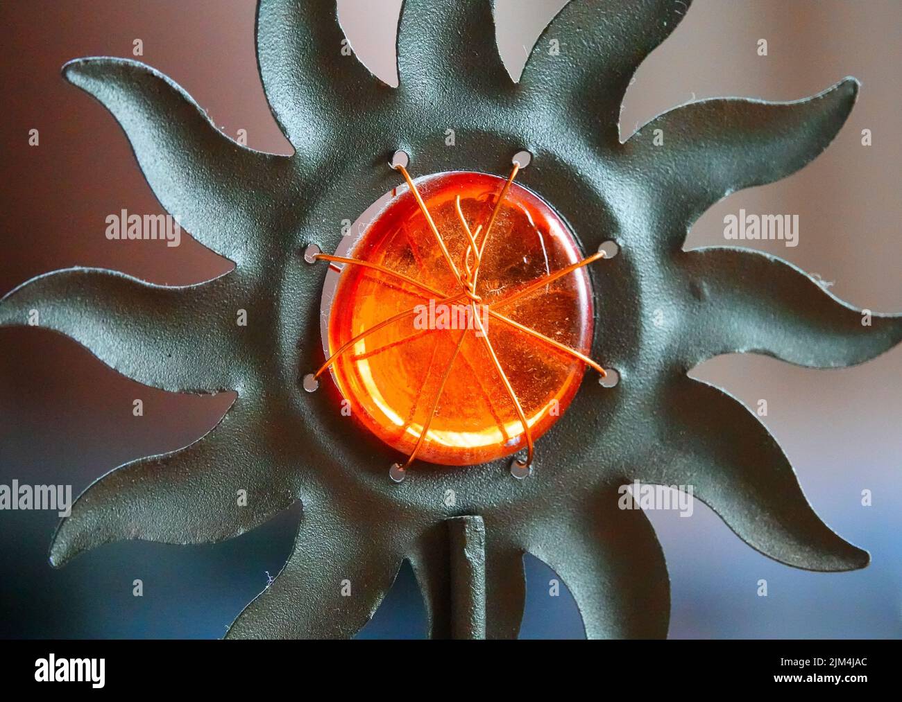 Picture shows a close-up of a handcrafted sun made of dark metal with ...