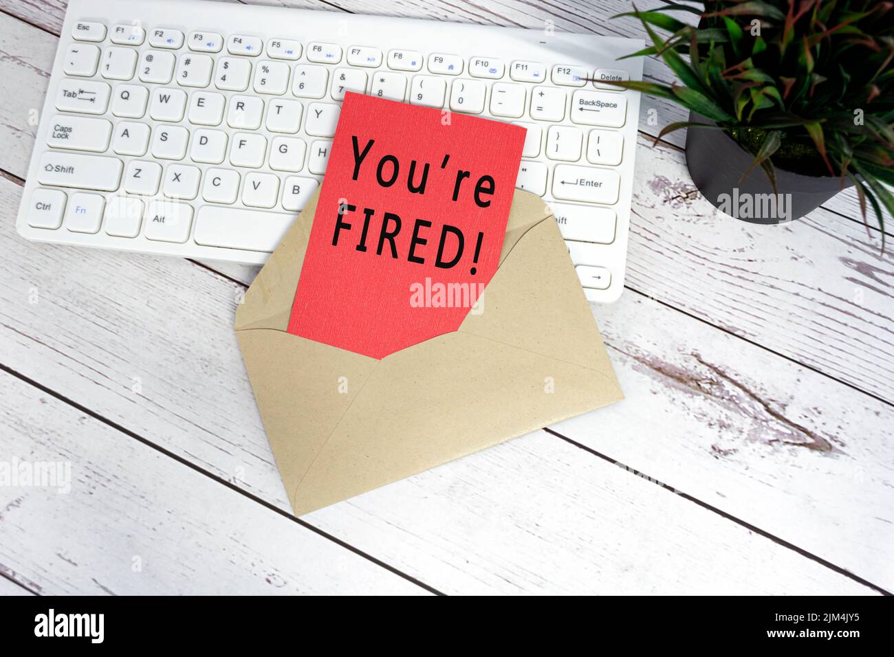 You are fired text on red note inside brown envelope with keyboard and ...