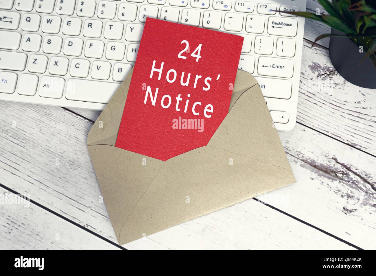 24 hours notice text on red note inside brown envelope with keyboard ...