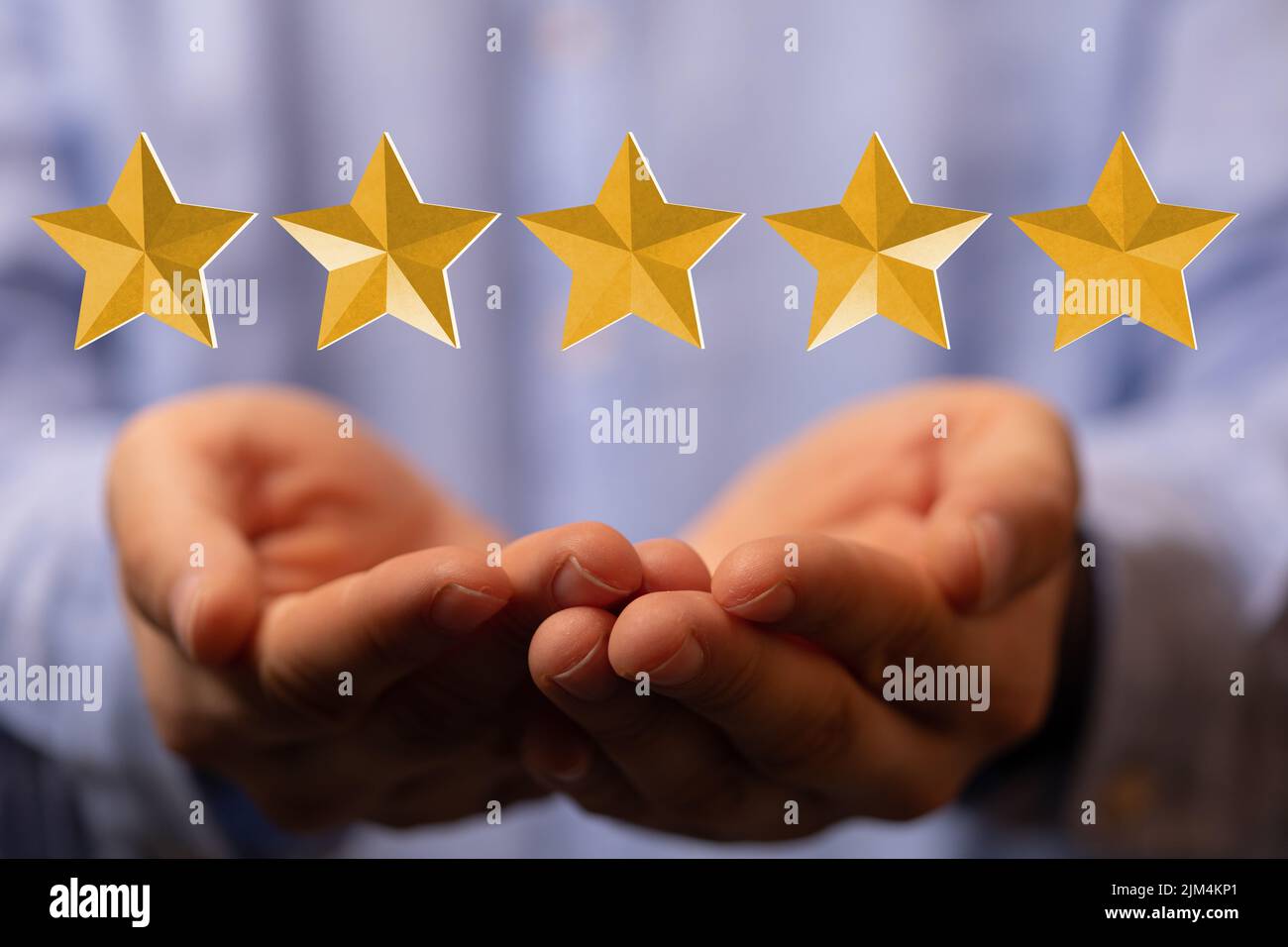 A person's hand with illustrative five stars floating above hands ...