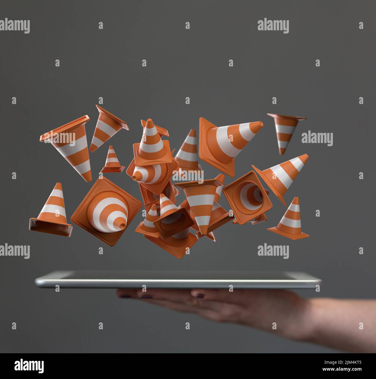 A hand holding a tablet with many illustrative traffic cones floating ...