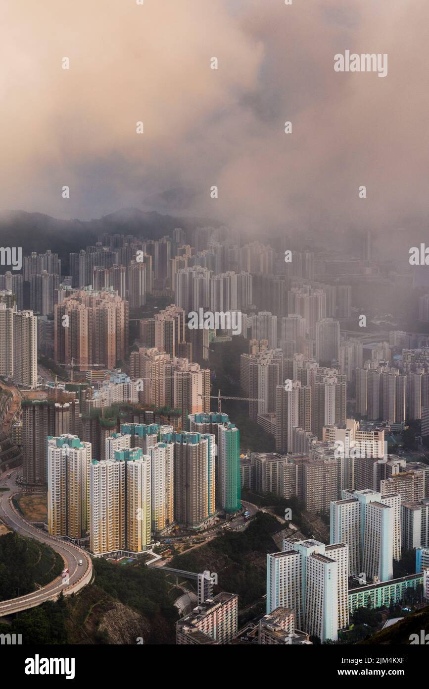 A vertical high-angle drone shot of some high buildings in misty ...