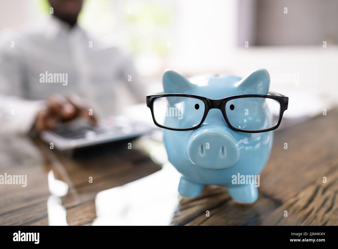 African Accounting Tax Advisor Using Calculator And Piggy Bank Stock ...