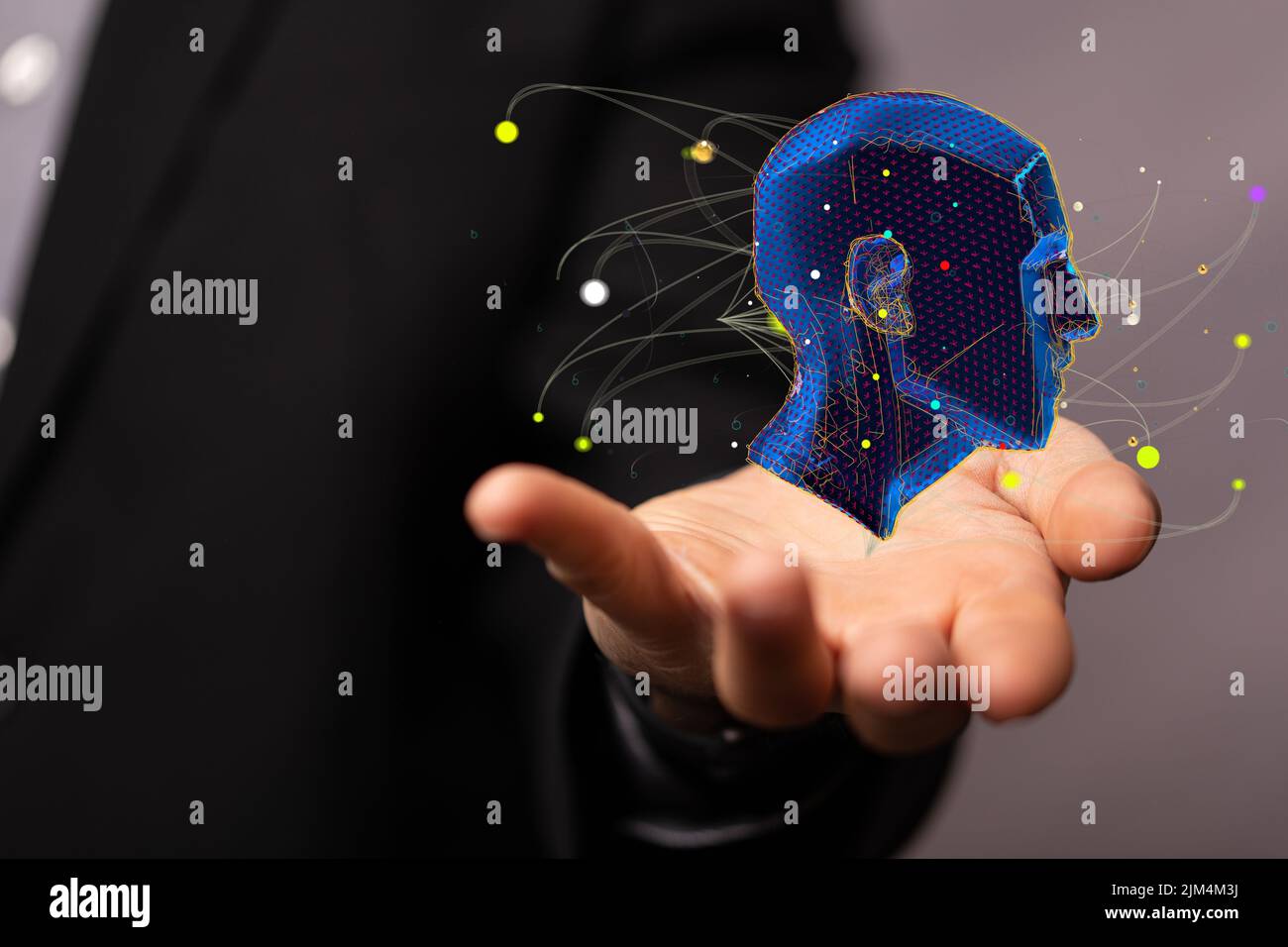 A person's hand with an illustrative cyber human head floating above ...