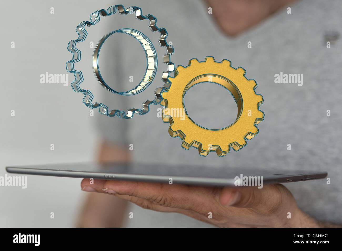 A hand holding a tablet with some illustrative gray gears floating above the display Stock Photo ...