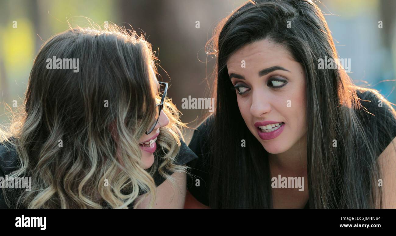 Friends gossiping talking to each other in conversation outside in the ...
