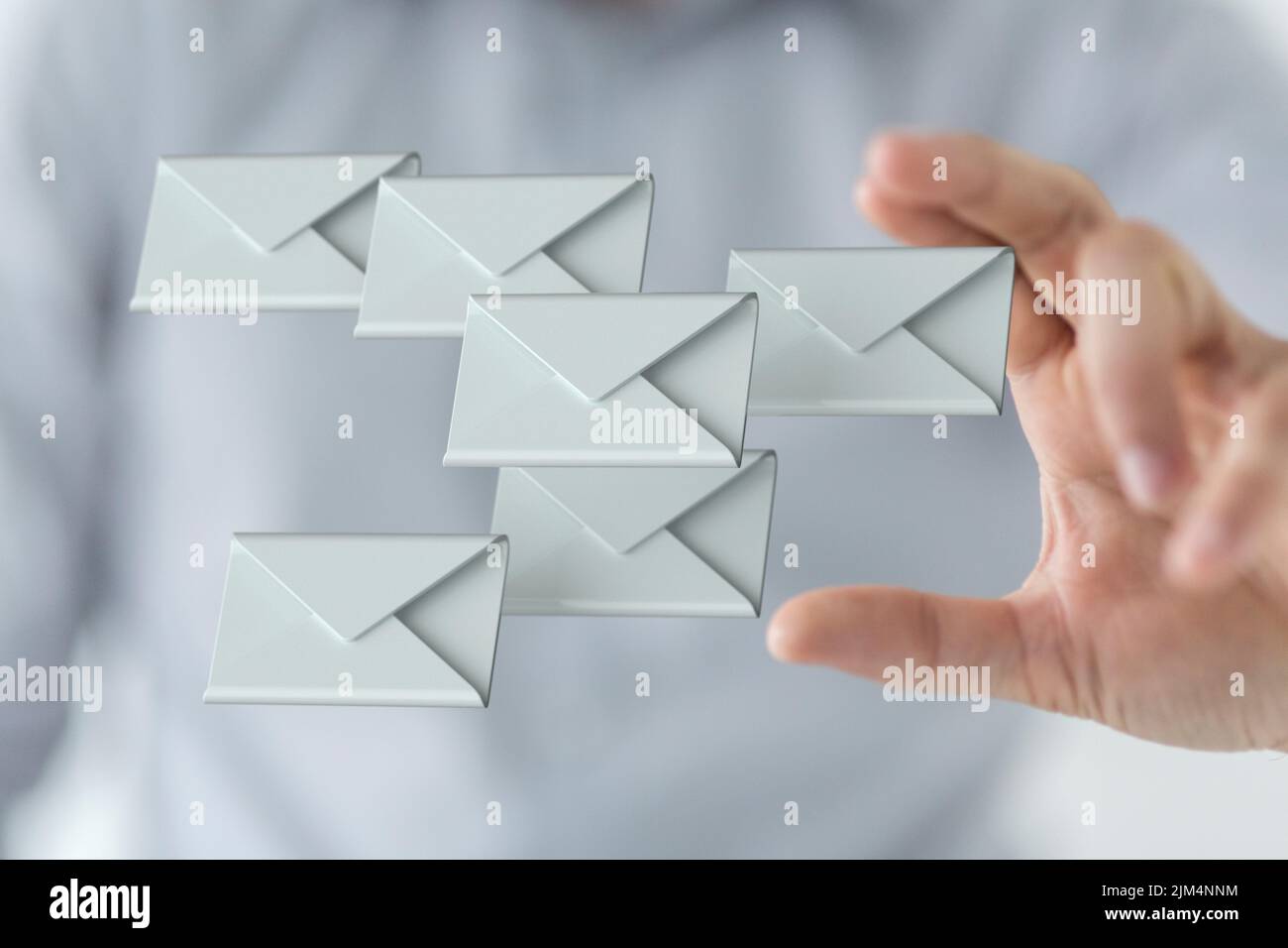 a shot of email symbols flying over mans hand Stock Photo - Alamy