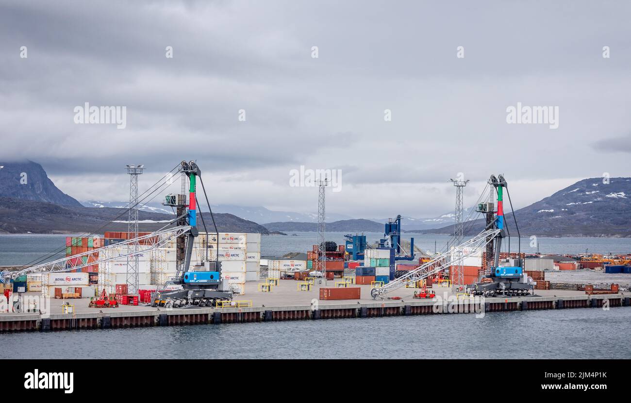 Containers stacked up at the port in Nuuk with snow capped mountains in ...