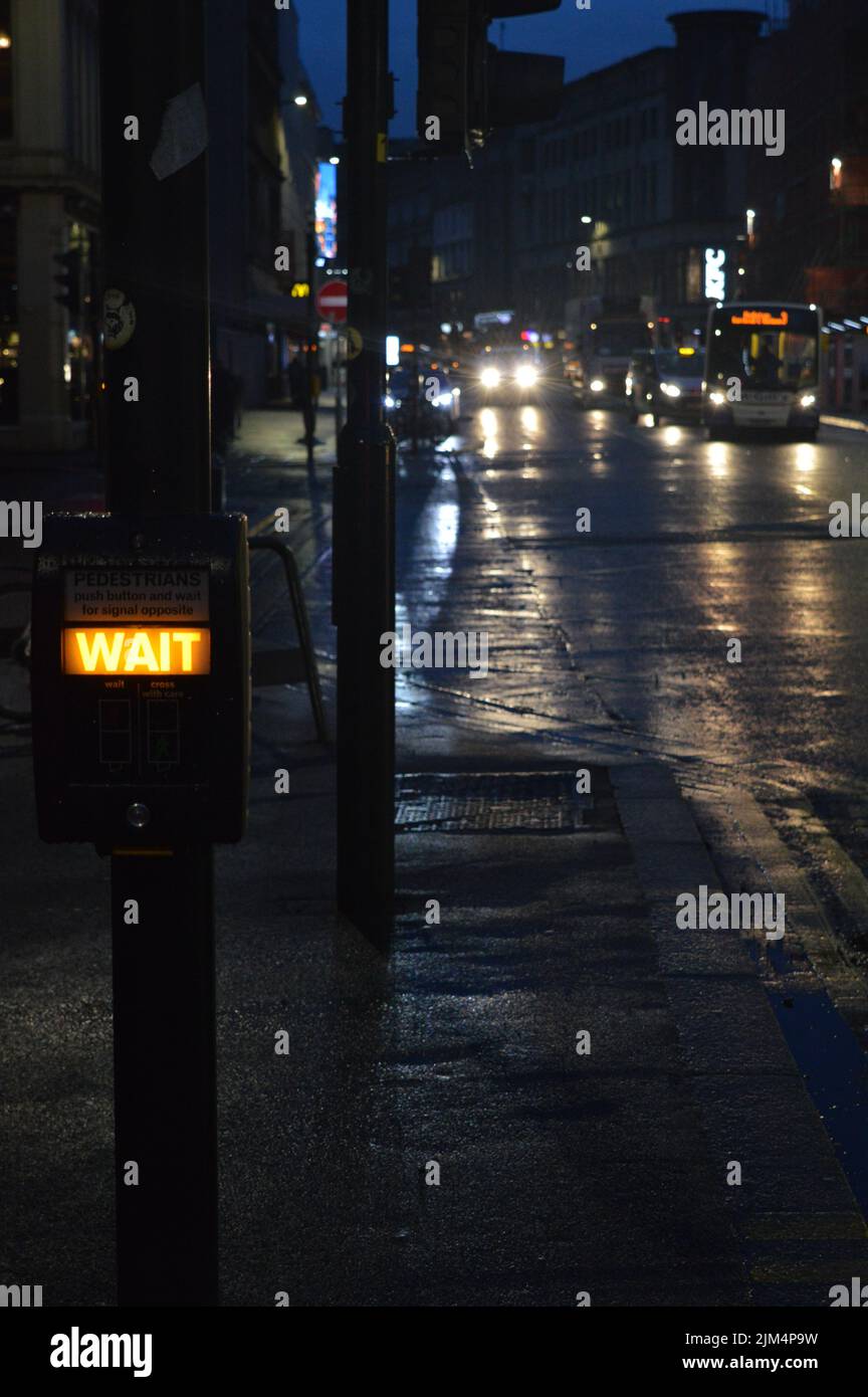 A vertical shot of pedestrian crossing wait sign in a street with ...
