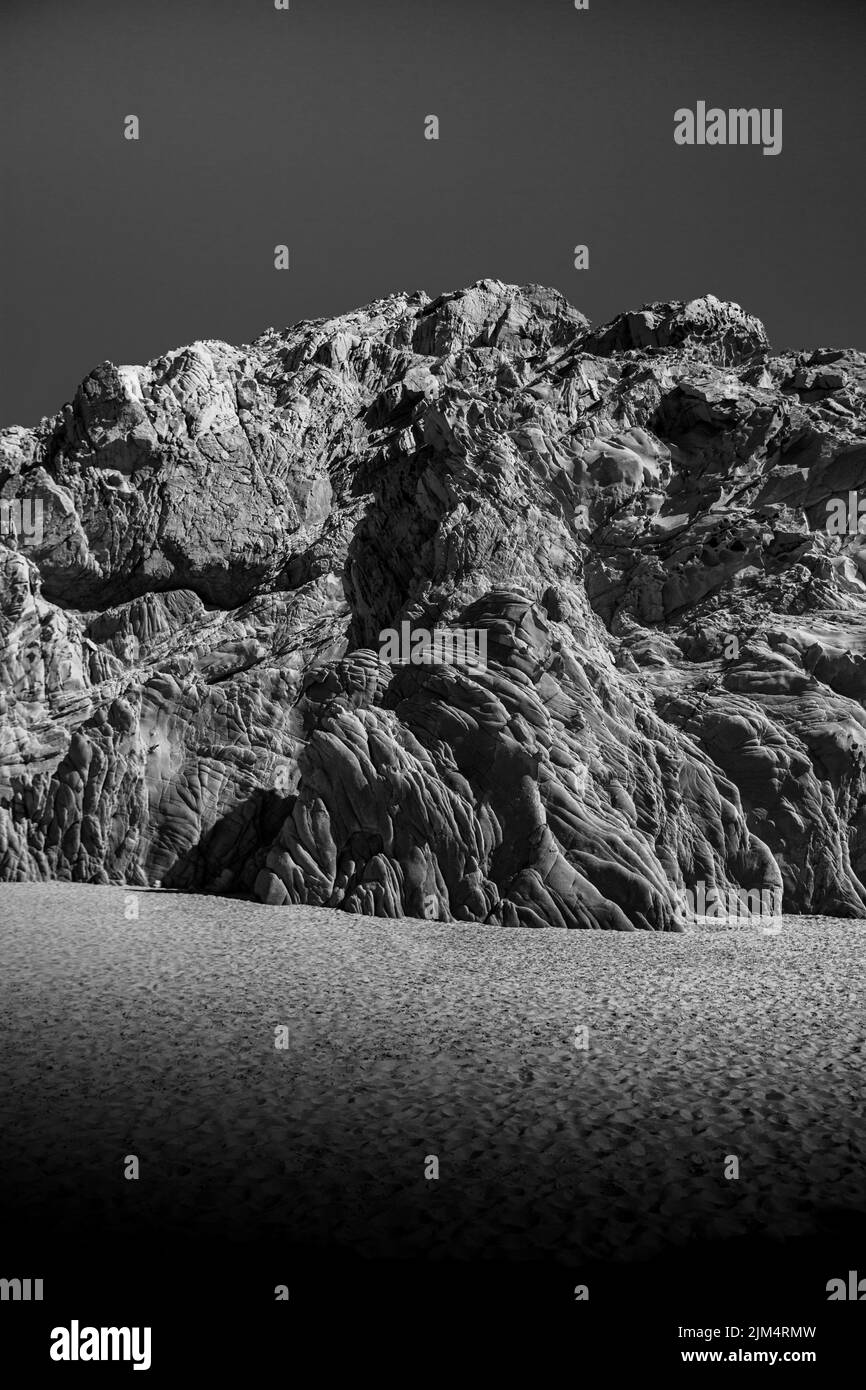 A vertical grayscale shot of the textured cliff in the desert Stock ...
