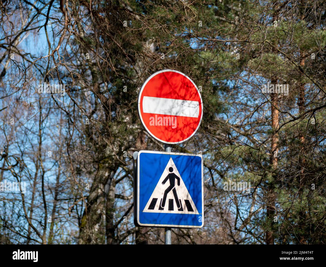 A round traffic red sign 'no entry to drivers' over blue crossing sign ...