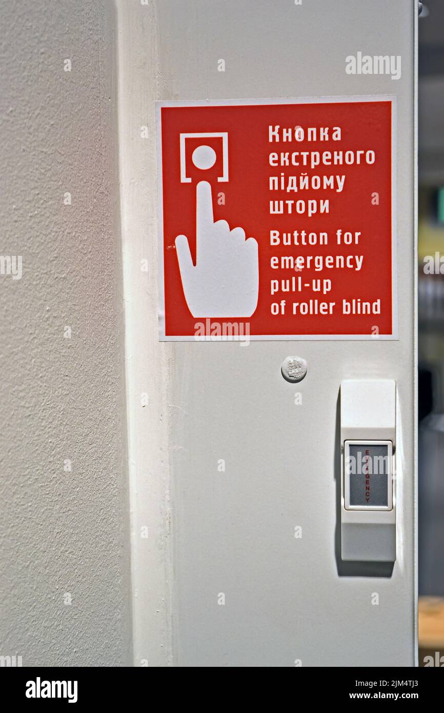 red button for emergency roller pull-up message closeup on the wall ...