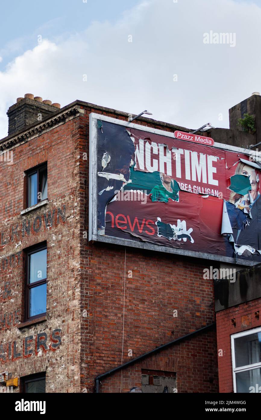 old brick apartment building in the city of Dublin with old billboard ...