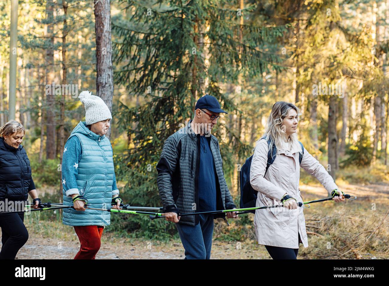 Side view of female coach, campers make Scandinavian walking, hold ...