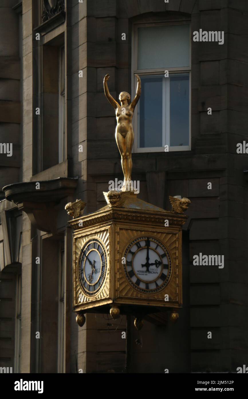 A European-style clock by the roadside features a figure with ...